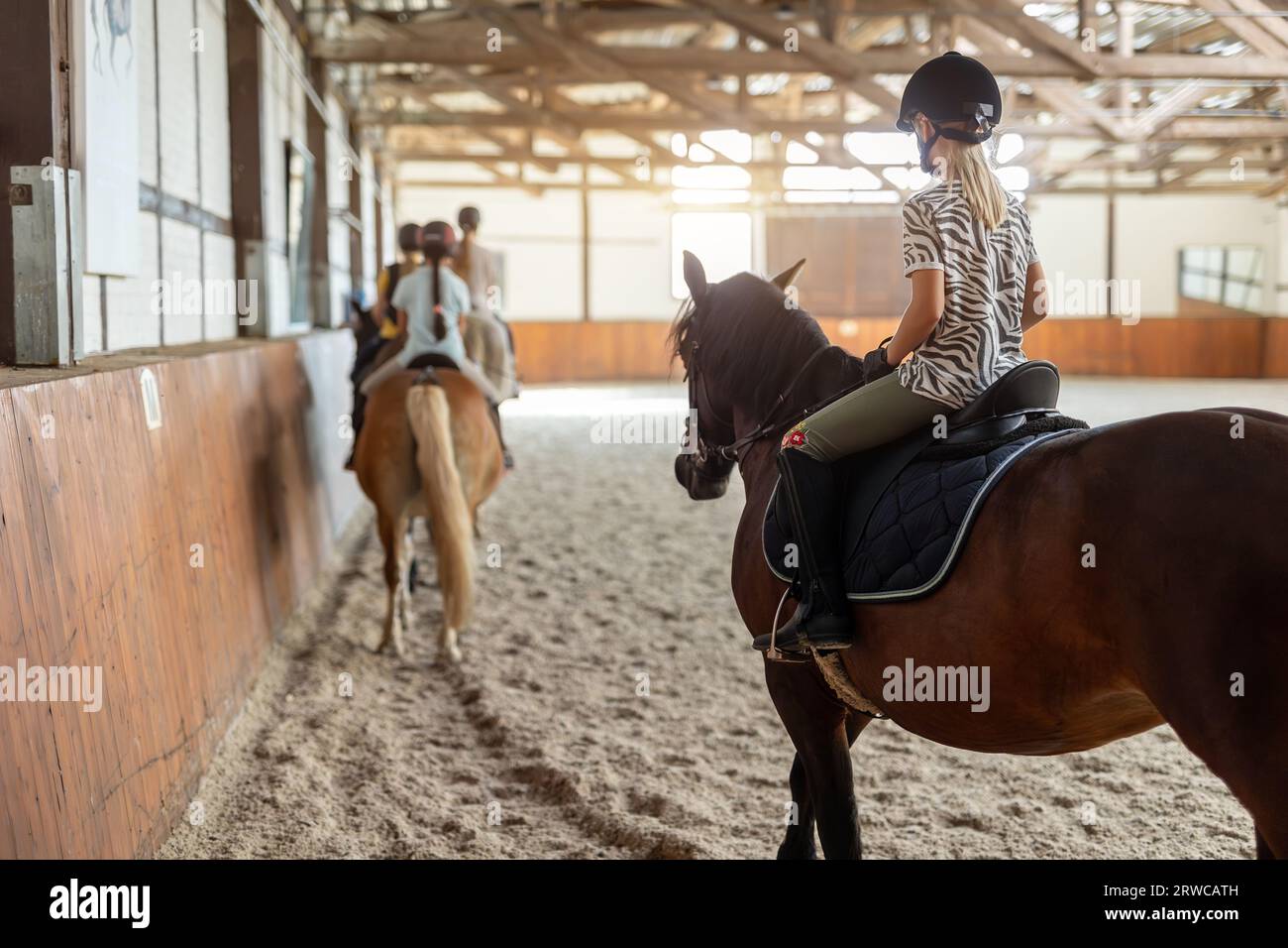 Horse riding school. Little children girls at group training equestrian ...