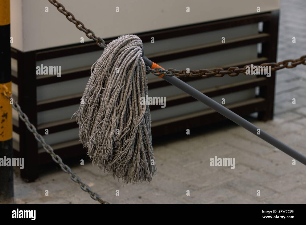 Dirty mop hanging from a chain used for mopping floors Stock Photo - Alamy