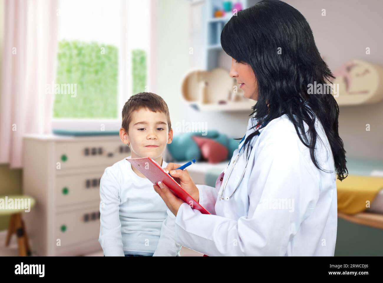 Doctor questioning boy and writing in clipboard isolated on white ...