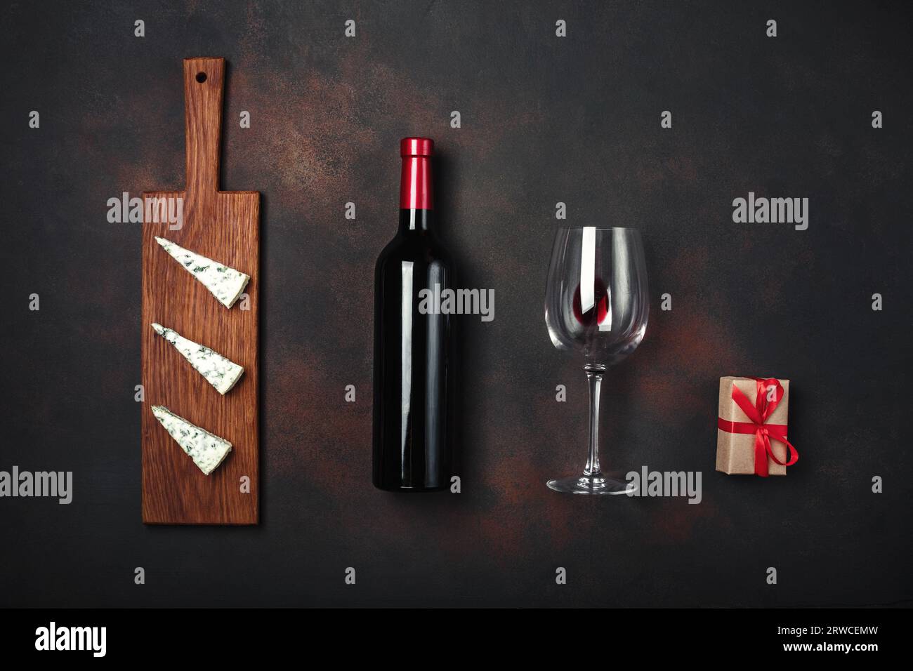 Bottle of wine, gift box ,blue stinky cheese and wineglass on rusty ...