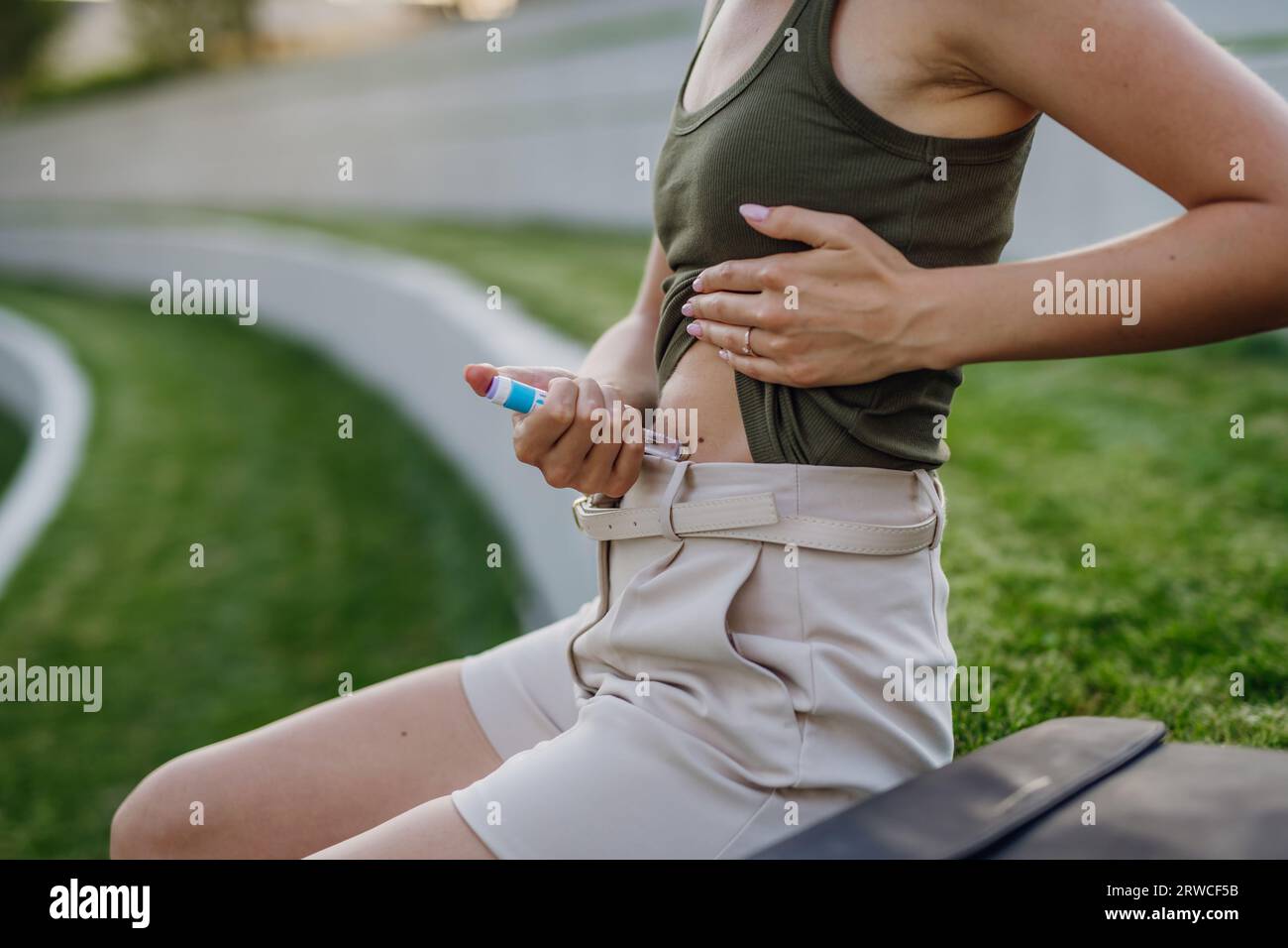 Woman injecting insulin in her belly outdoors Stock Photo - Alamy