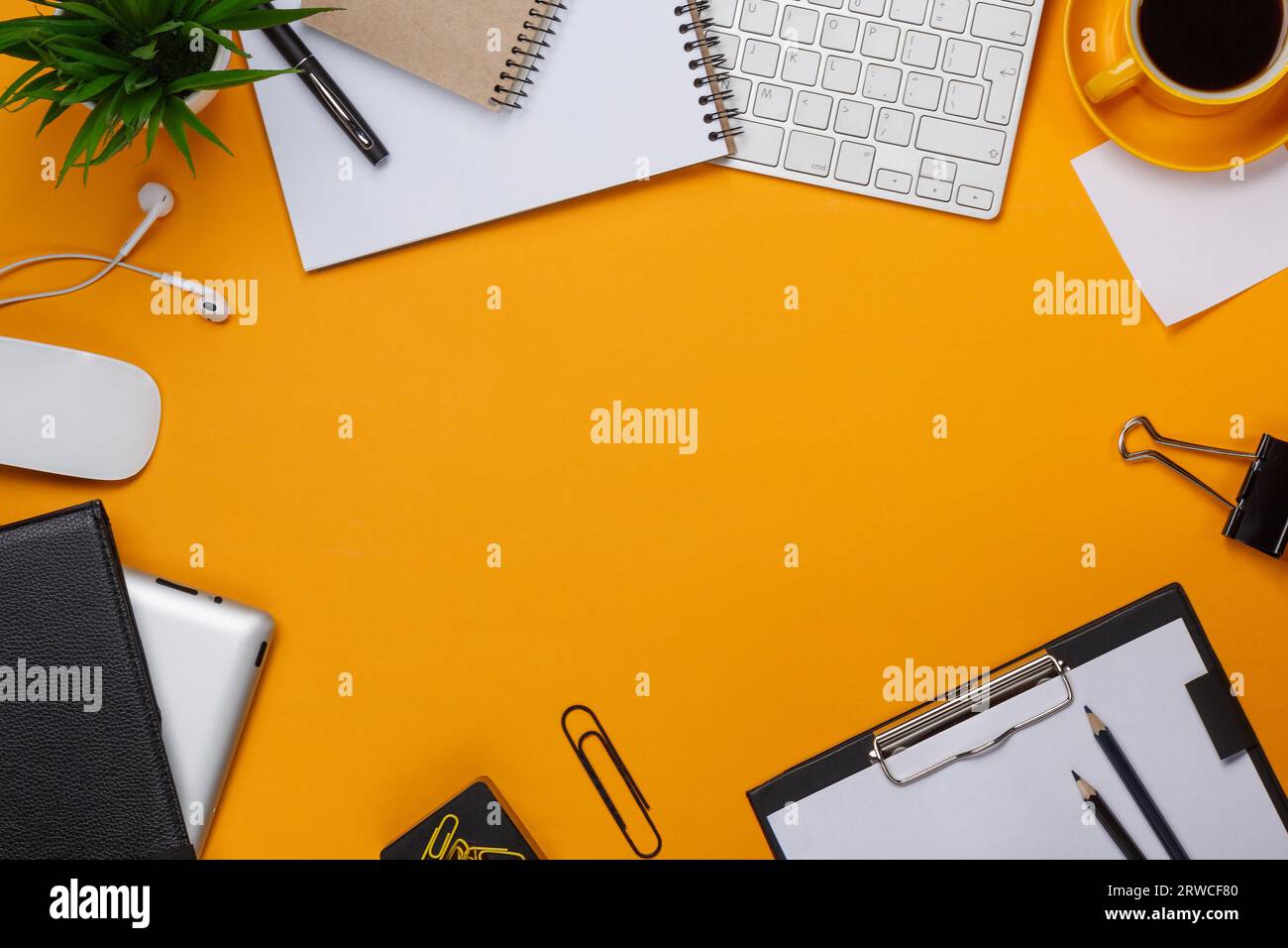 yellow background mess on desktop keyboard mouse cup of coffee business ...