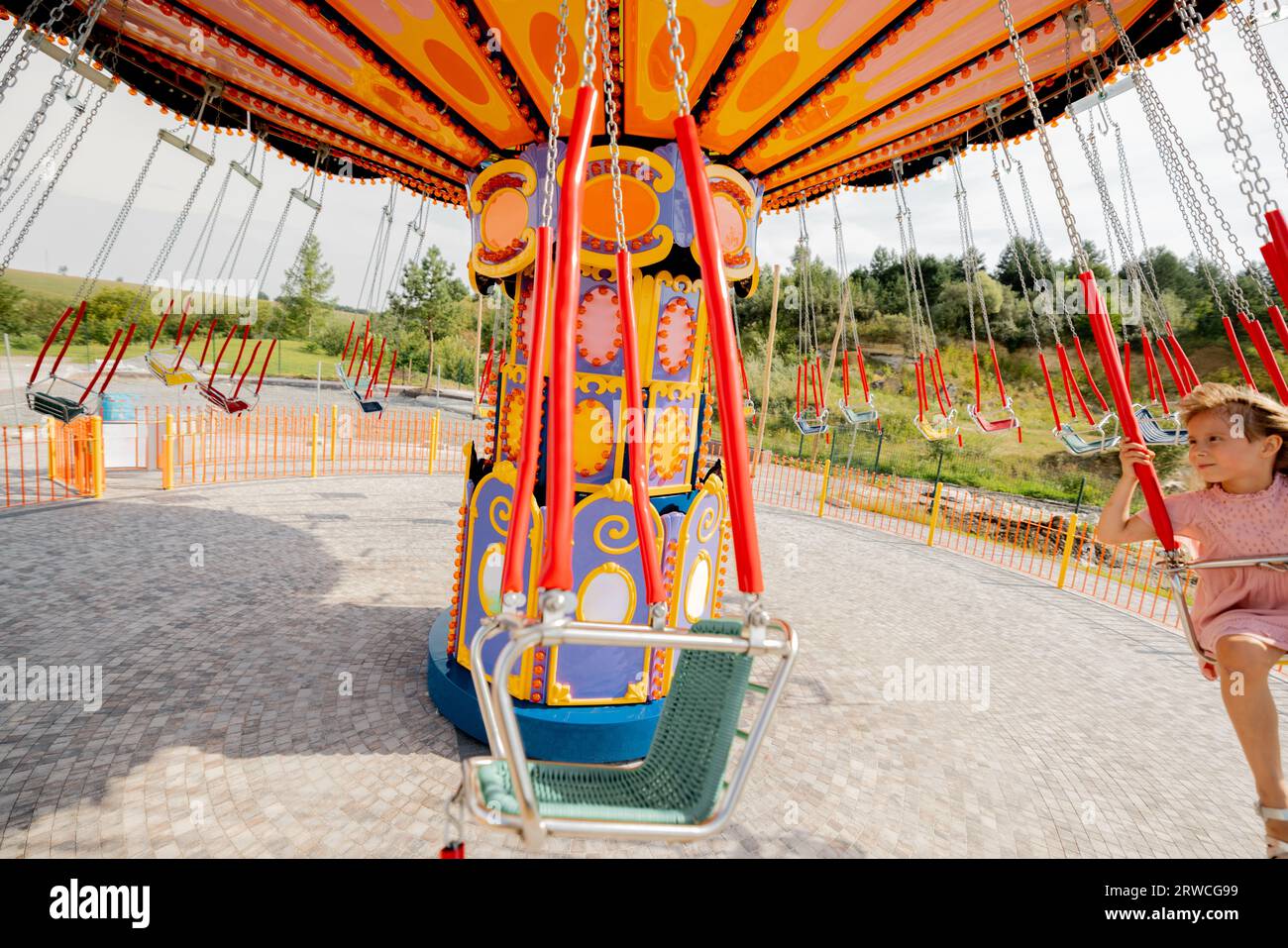 Kids riding on colorful amusement carousel Stock Photo - Alamy