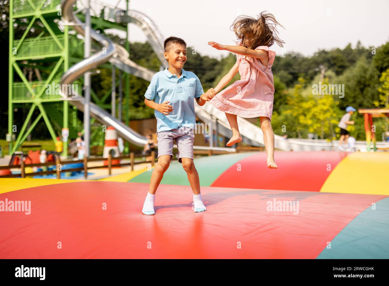 Kids jumping on inflatable trampoline in amusement park Stock Photo - Alamy