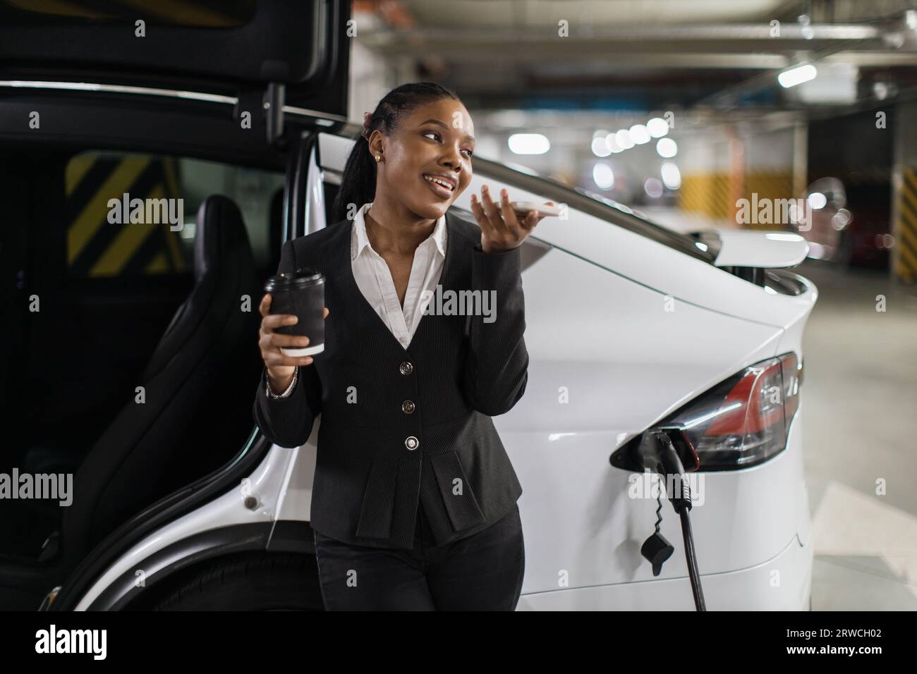 Worker talking on phone speaker during coffee break near EV Stock Photo ...