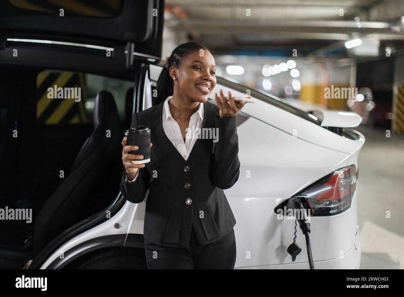 Worker talking on phone speaker during coffee break near EV Stock Photo ...