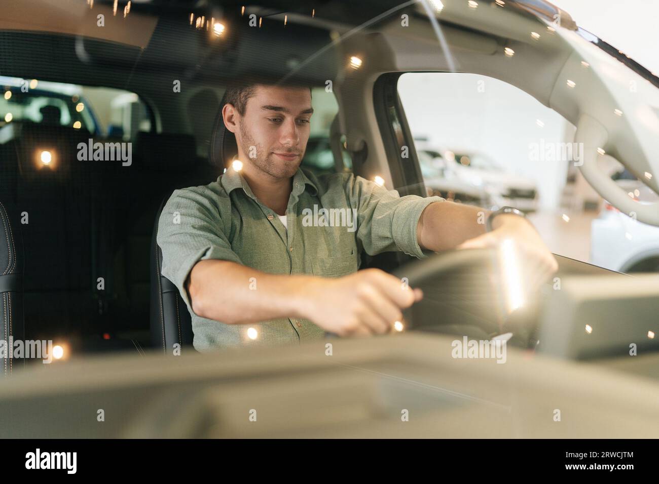 Portrait through windshield of pensive customer male client putting ...