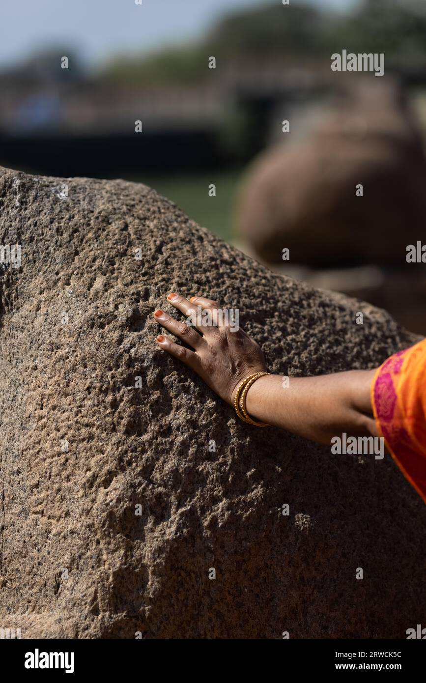 The woman touches a stone with her hand on a sunny day. Close-up of the ...