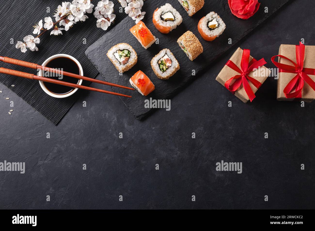 Set of sushi, maki rolls, gift boxes with branch of white flowers on stone table Top view Stock ...