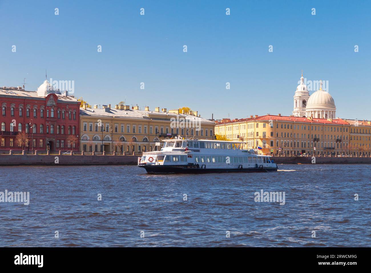 Neva river coastal view with passenger boat and domes of the Church of ...
