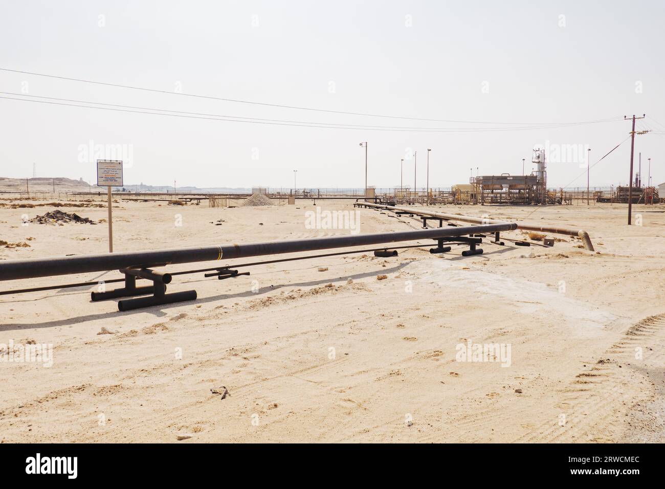 a natural gas pipeline runs across desert sand in the Middle Eastern ...