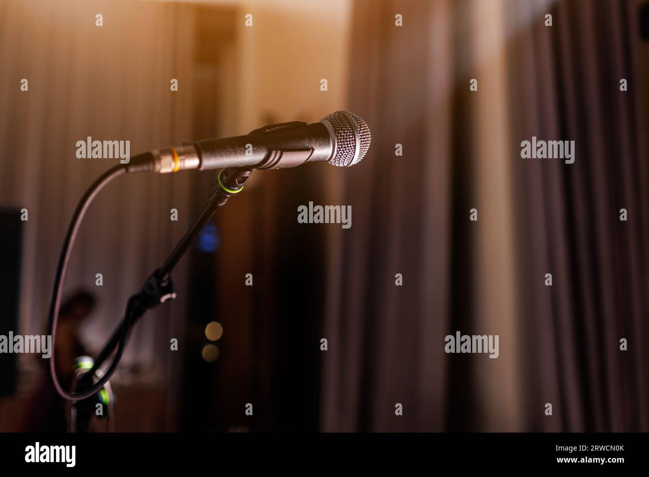 Microphone on stand on stage close up with searchlight light ...