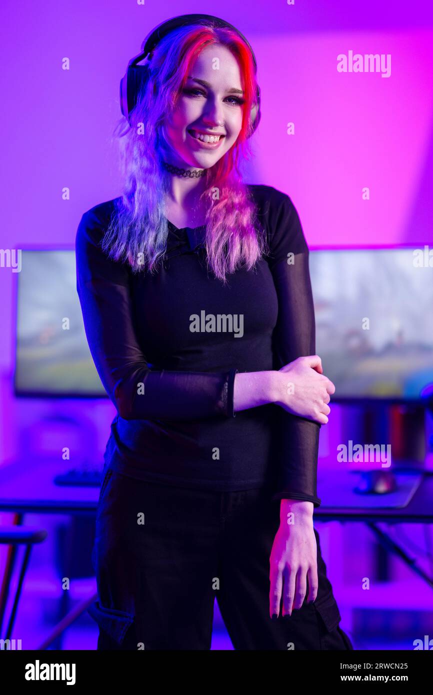 Portrait of a smiling e-sport gamer girl in front of her computer in ...