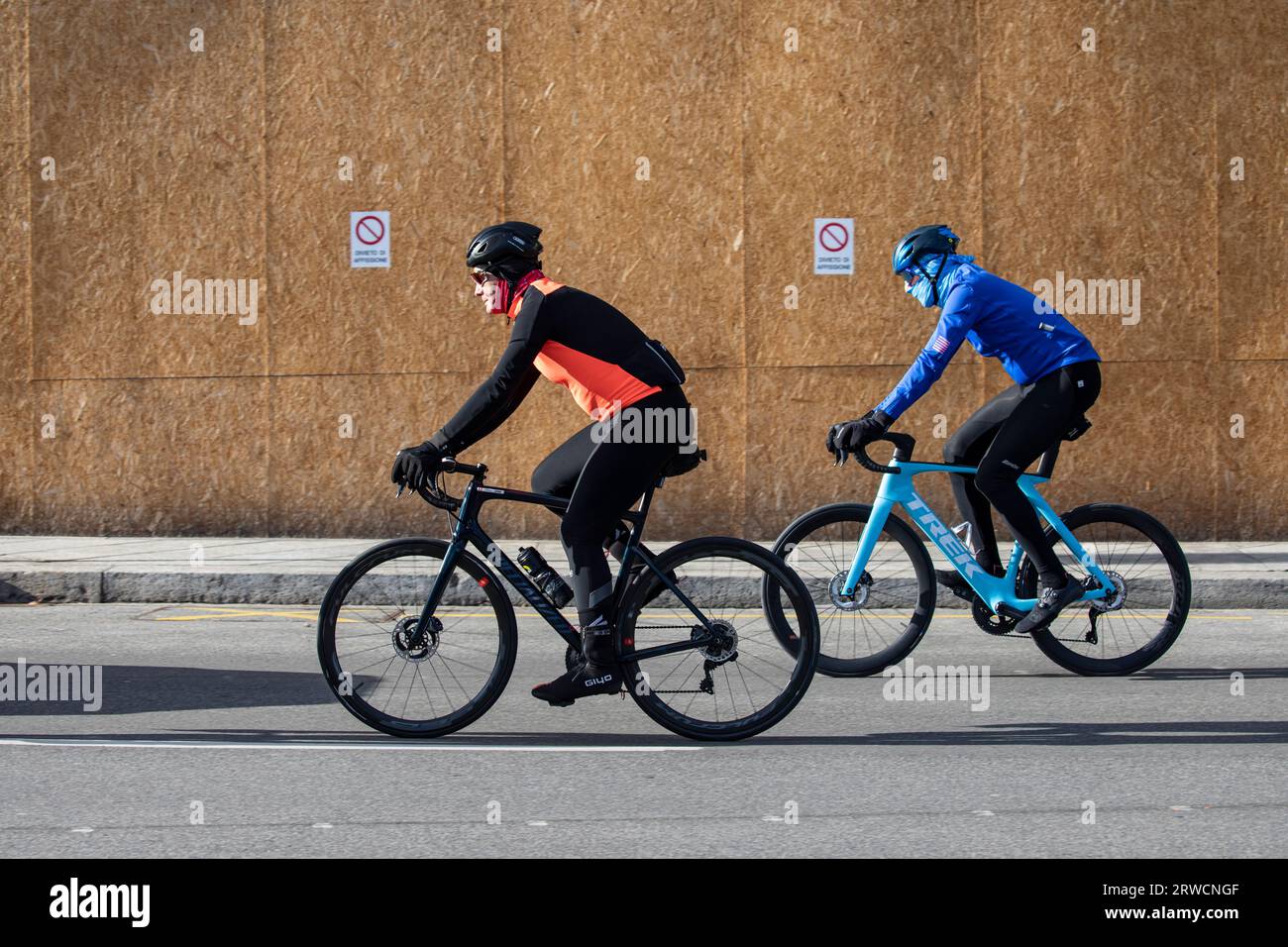 Lugano, Switzerland, 21 January 2023: Men cycling past on the street in ...