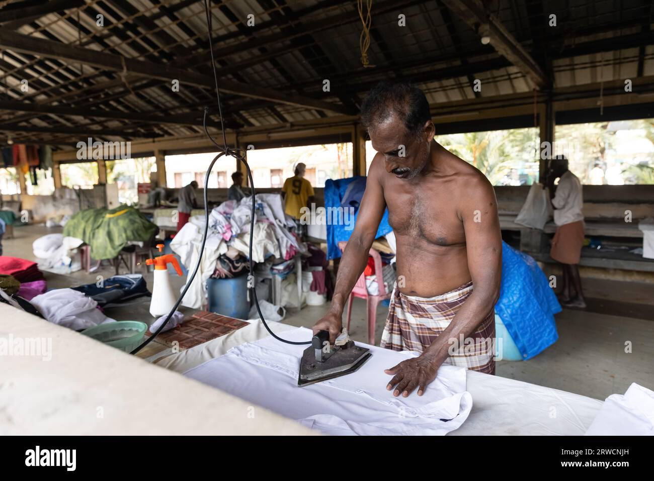 KOCHI, INDIA - JANUARY 28, 2023: A man is manually ironing laundry at ...
