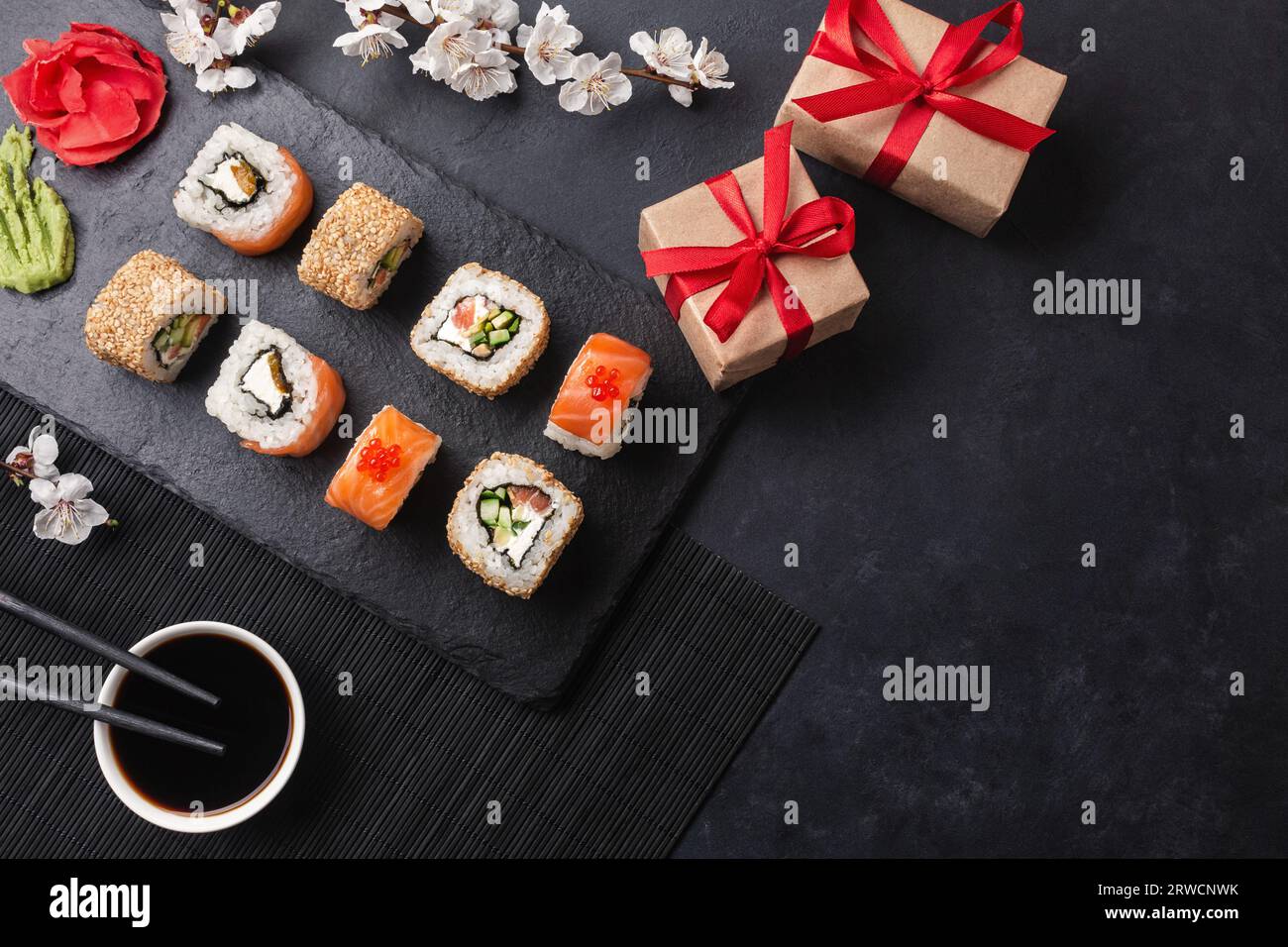 Set of sushi, maki rolls, gift boxes with branch of white flowers on stone table Top view Stock ...