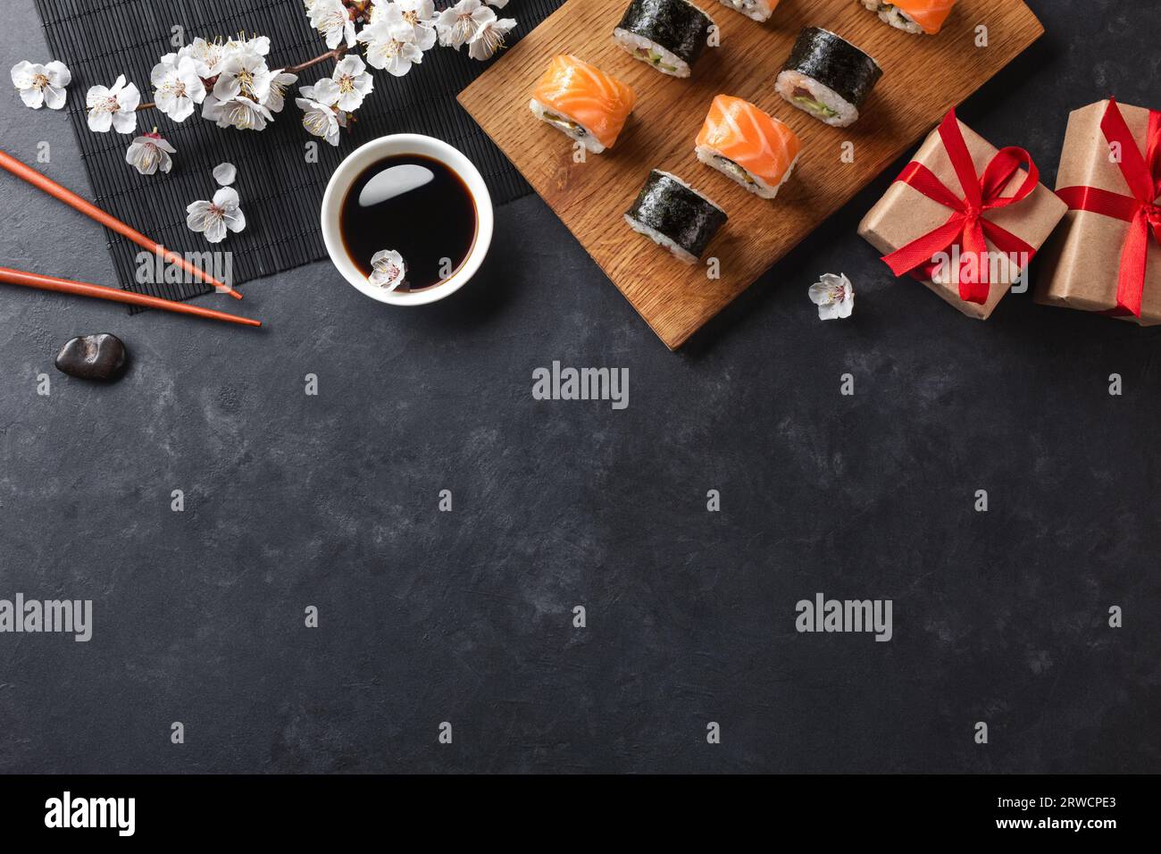 Set of sushi, maki rolls, gift boxes with branch of white flowers on stone table Top view Stock ...