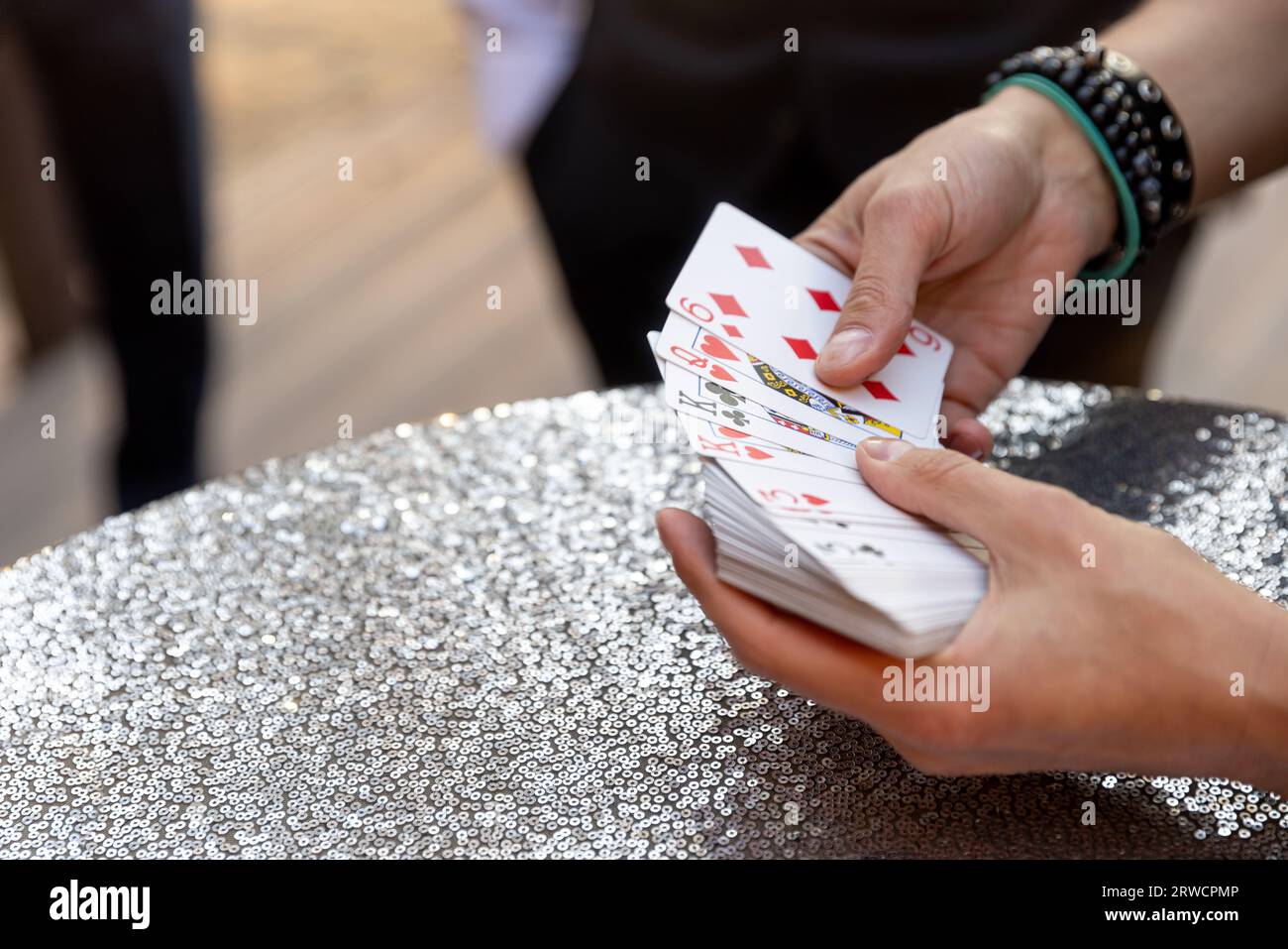 male hands holding playing card table silver Stock Photo - Alamy
