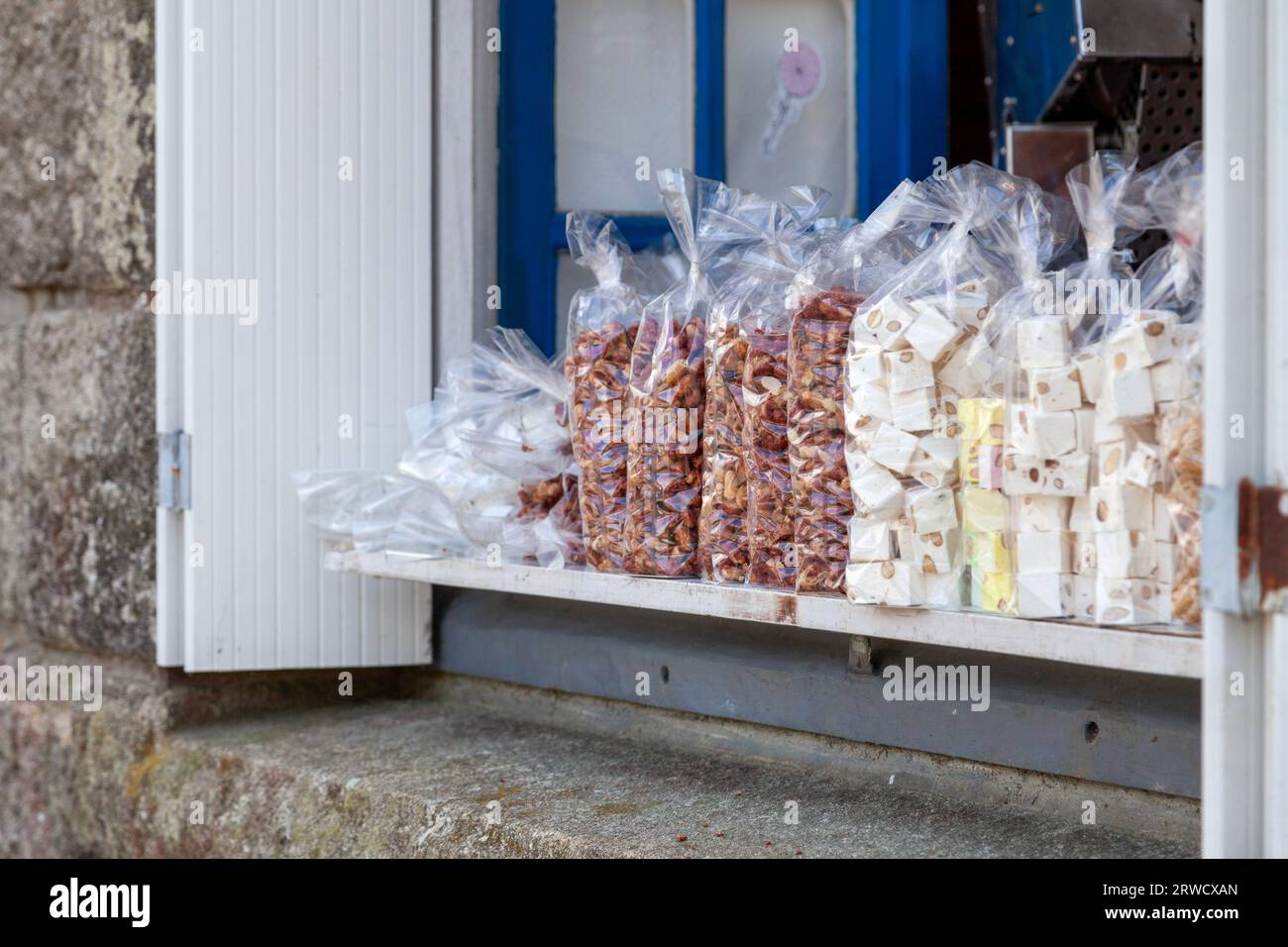 Bags of nougats and pralines on sale on the window sill of a candy shop ...