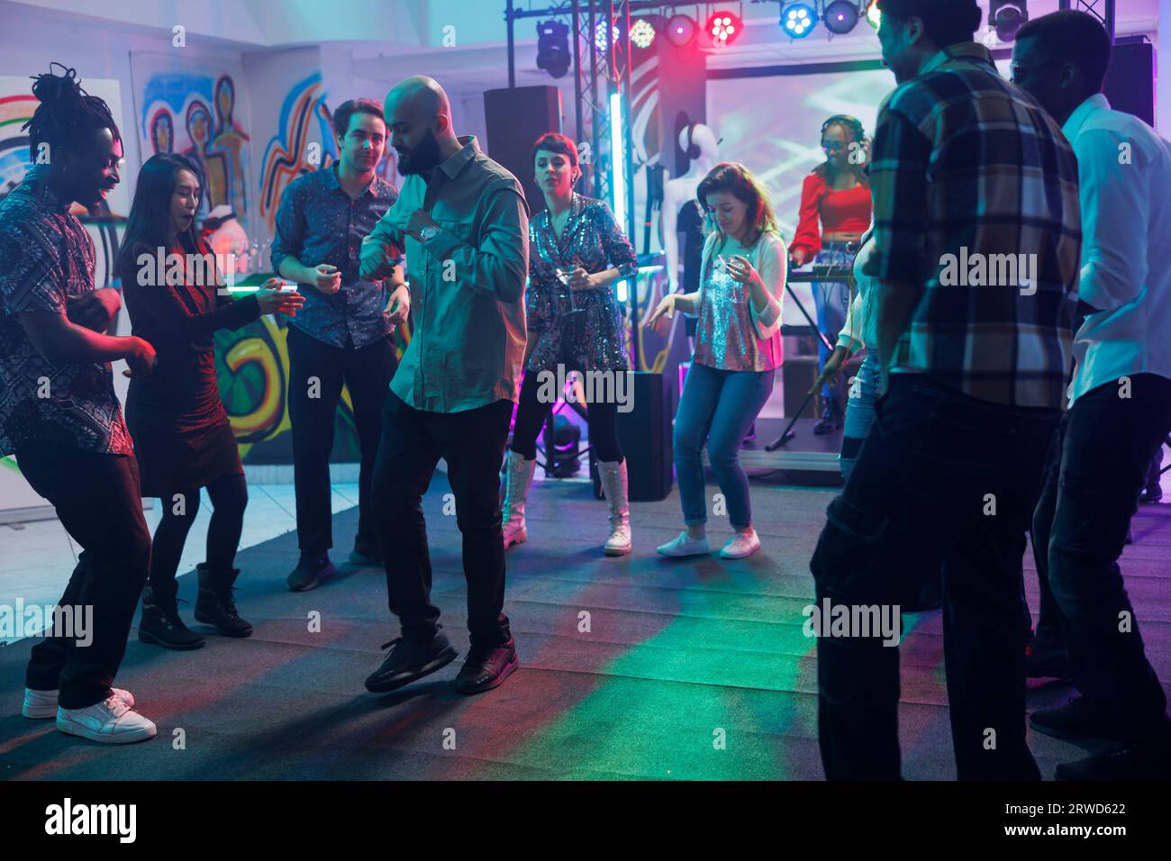 Young clubbers dancing at discotheque in nightclub and partying ...