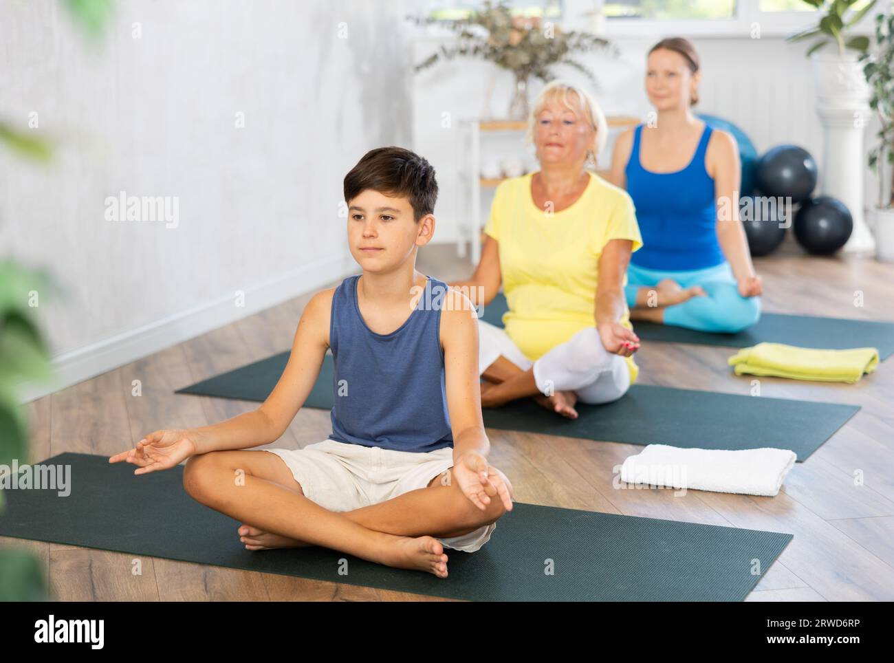 Family three generations do half lotus position Sidhasana with hands ...