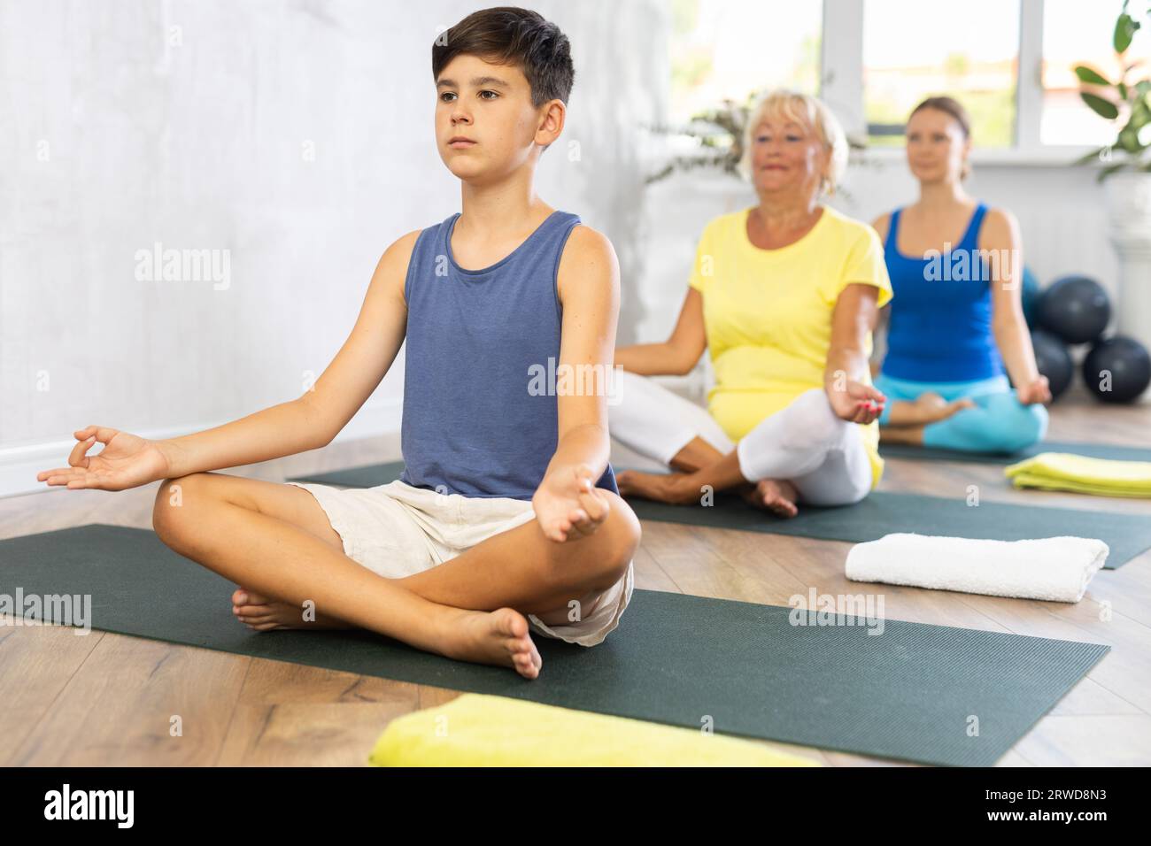 Family three generations do half lotus position Sidhasana with hands ...
