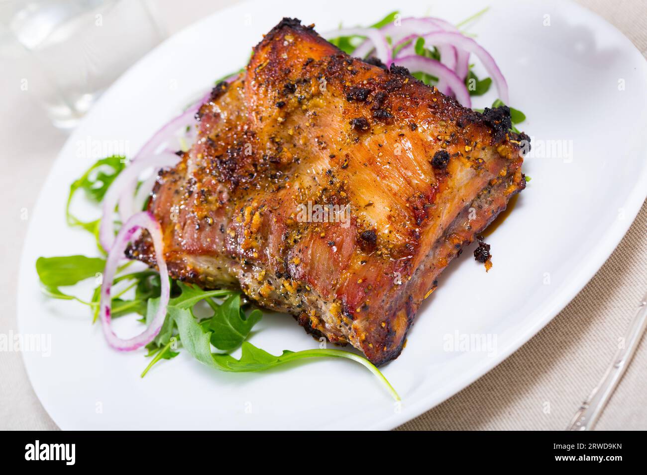 Roasted pork rack of ribs with greens Stock Photo - Alamy