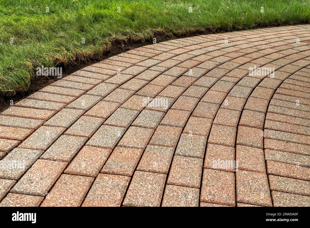 Brick pavers arranged in a curving pattern Stock Photo - Alamy