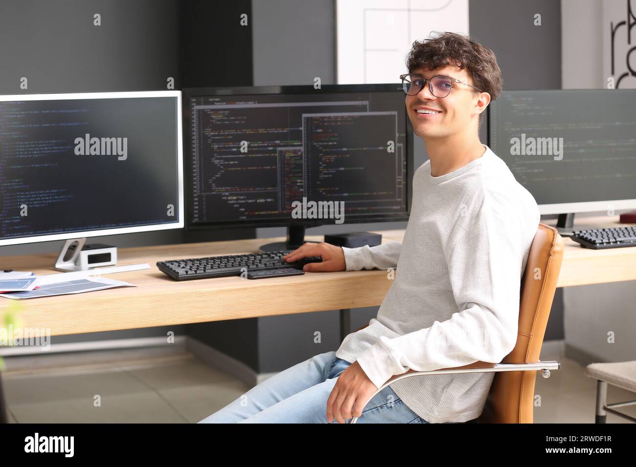 Male programmer working at table in office Stock Photo - Alamy