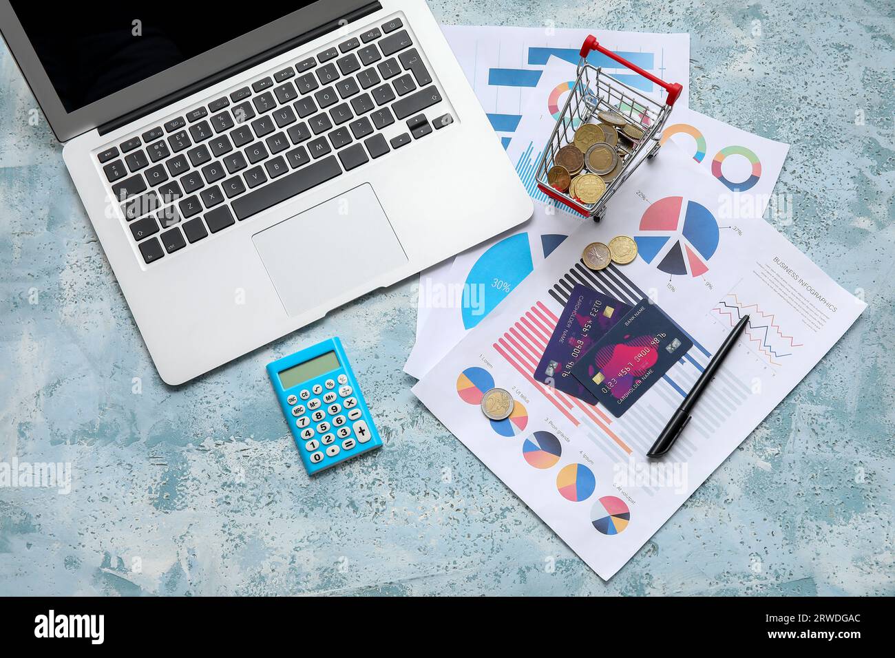 Credit cards, calculator, laptop and charts on blue grunge table. House ...