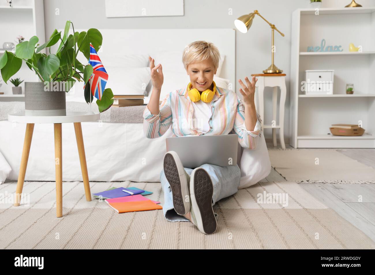 Mature woman learning English language online in bedroom Stock Photo ...