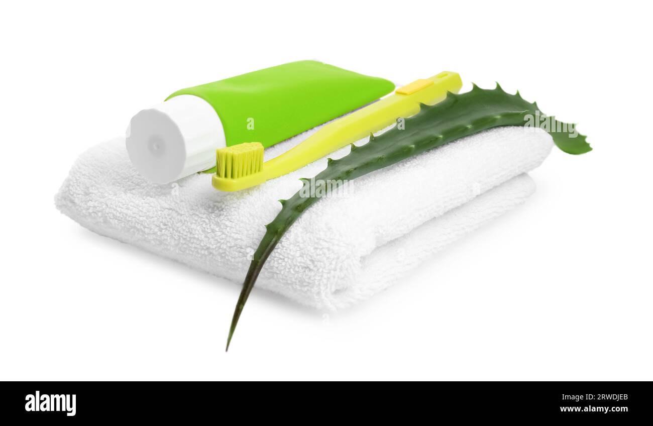 Tube of toothpaste, brush, aloe vera leaf and towel on white background ...