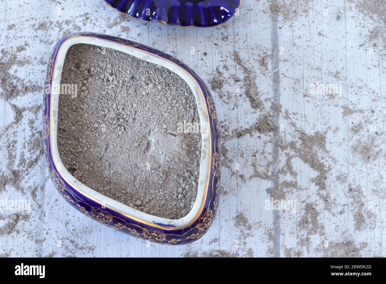 Pile of ashes in an ancient old-fashioned pot isolated on a light gray ...