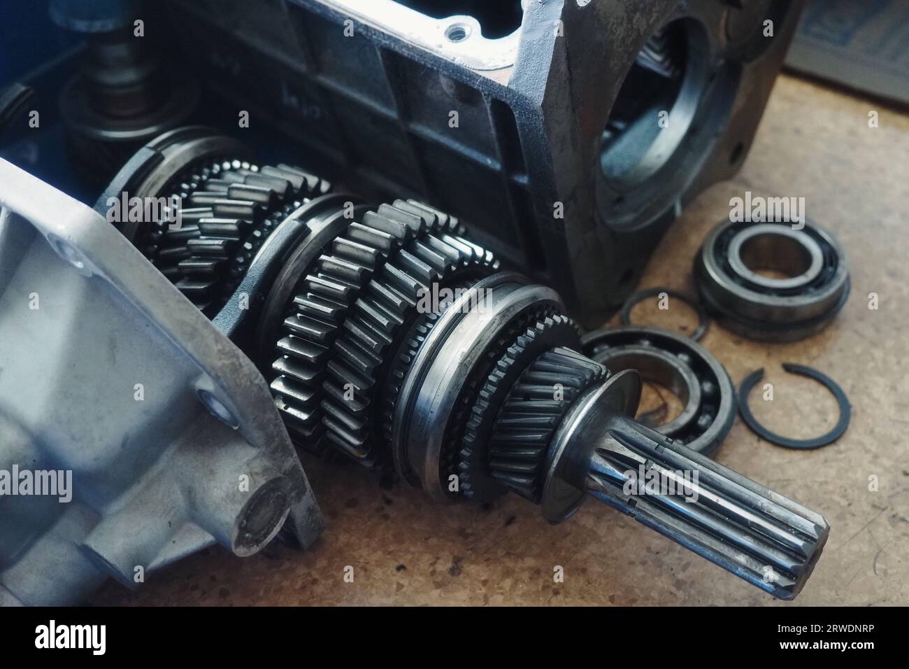 Gear spare part for car lies on workbench. Gears and transfer case ...