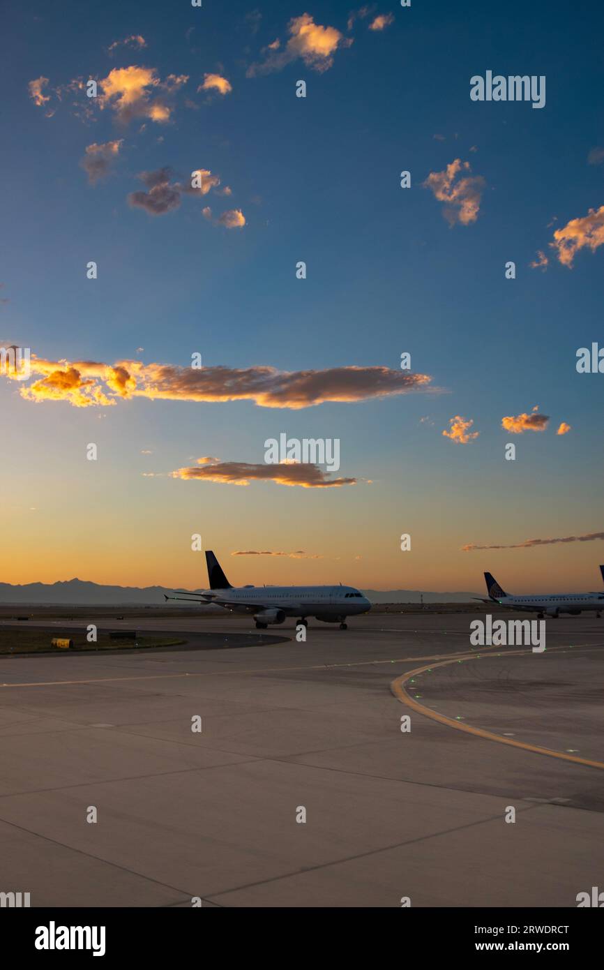The sunset over Denver Airport, reflecting in the metal airplane wing ...