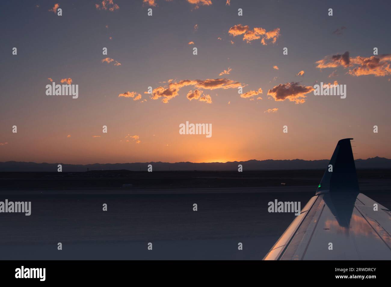 The sunset over Denver Airport, reflecting in the metal airplane wing ...