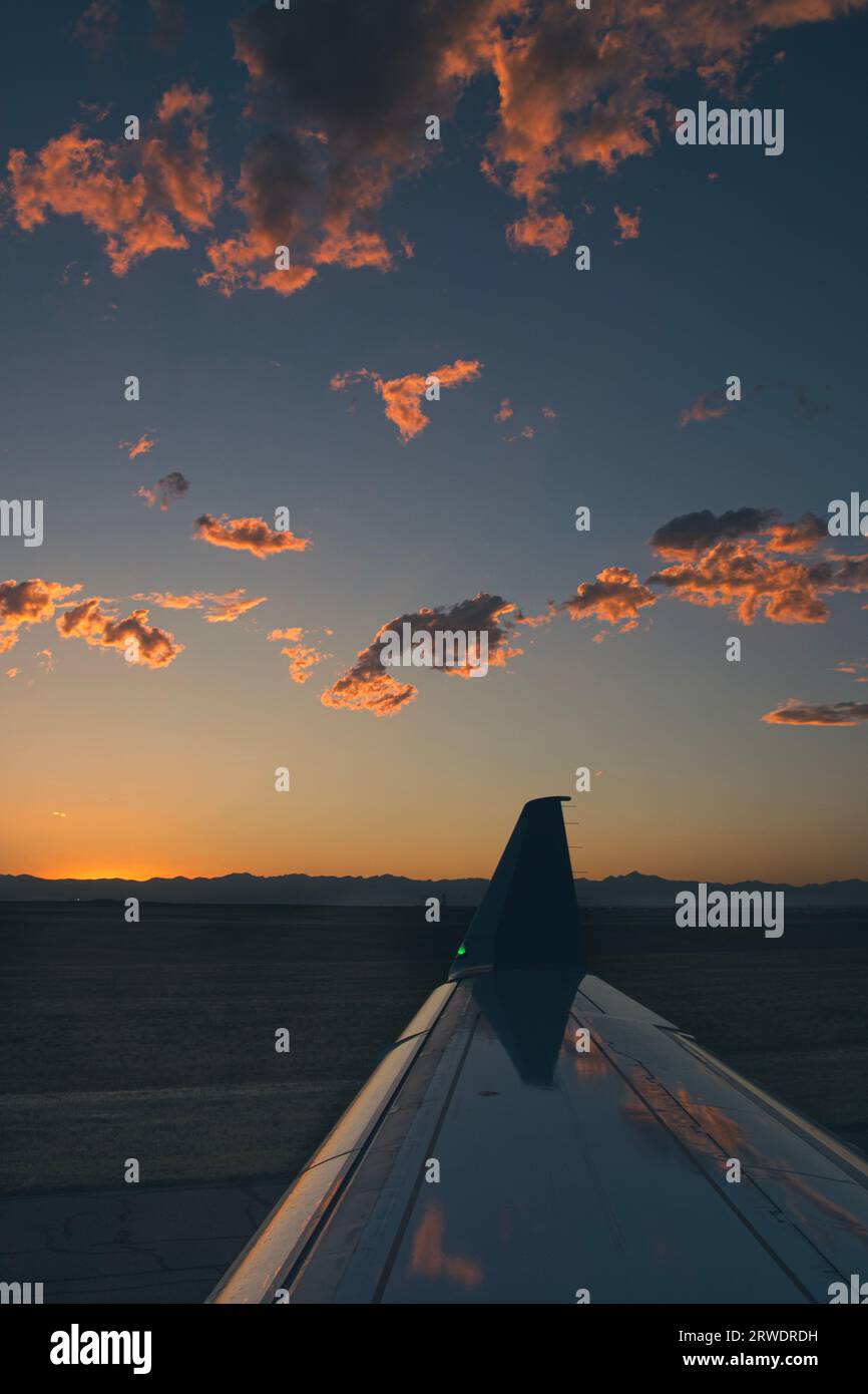 The sunset over Denver Airport, reflecting in the metal airplane wing ...