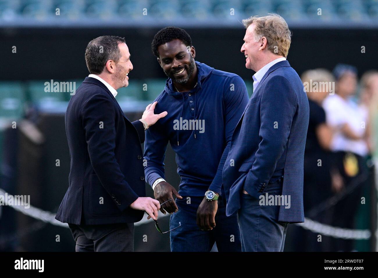 Former NFL football player Michael Vick, center, speaks with NFL ...