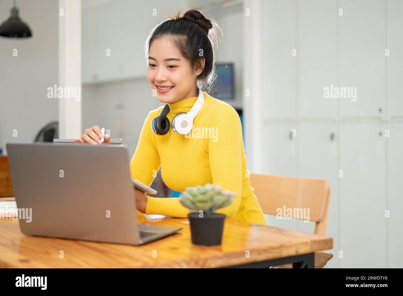 An attractive young Asian female university student working on her ...