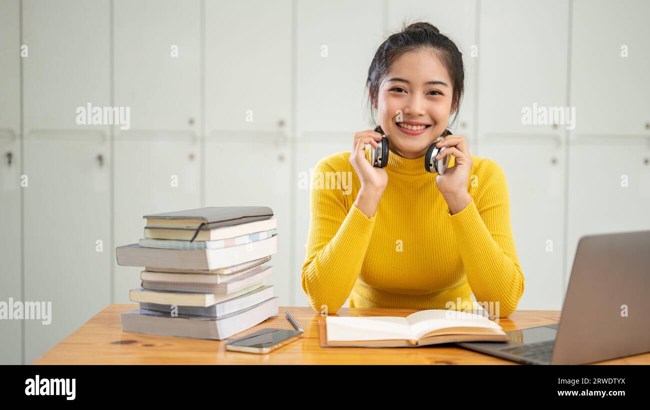 A beautiful and cheerful young Asian female university student smiles ...
