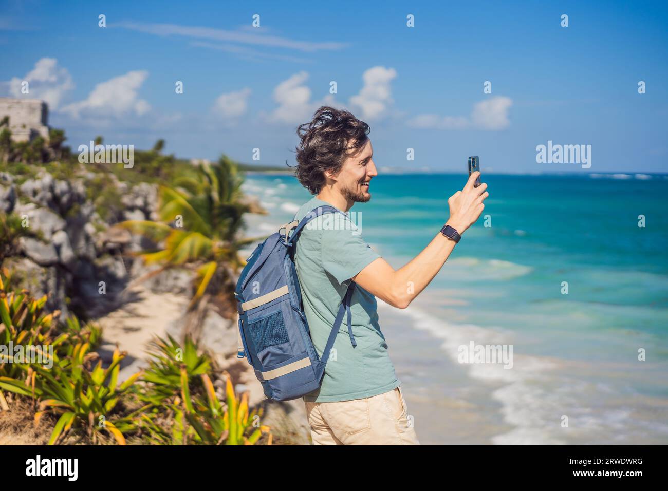 Male tourist enjoying the view Pre-Columbian Mayan walled city of Tulum ...