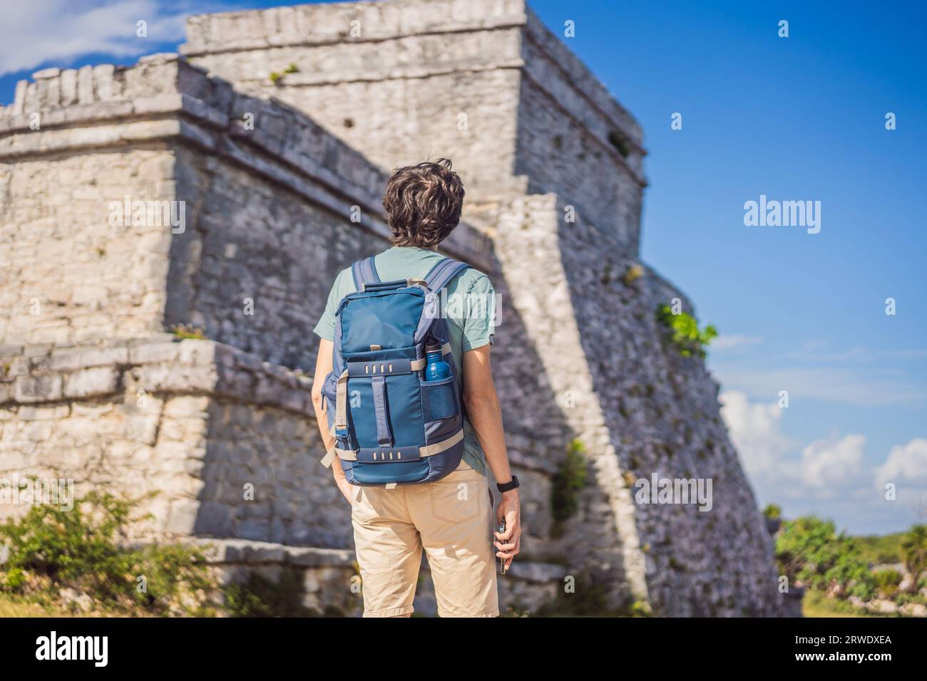 Male tourist enjoying the view Pre-Columbian Mayan walled city of Tulum ...