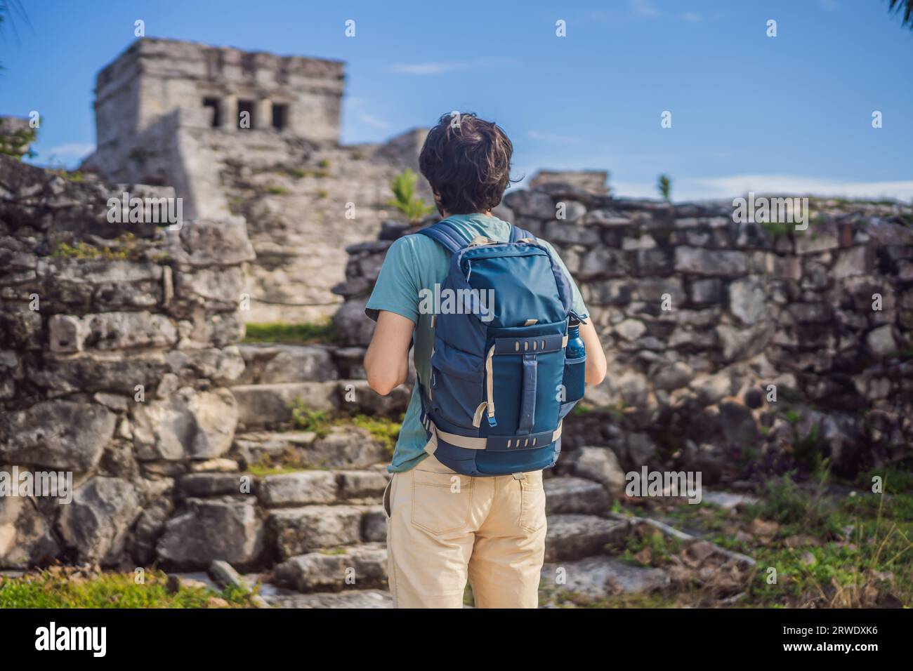 Male tourist enjoying the view Pre-Columbian Mayan walled city of Tulum ...