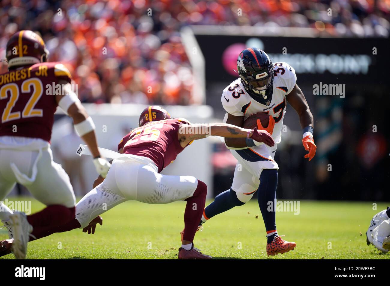 Washington Commanders cornerback Benjamin St-Juste (25) stops Denver Broncos running back ...