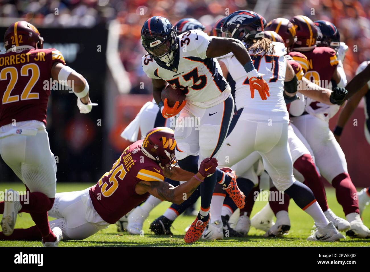 Washington Commanders cornerback Benjamin St-Juste (25) stops Denver Broncos running back ...