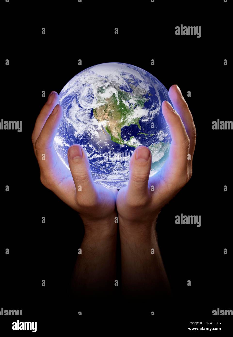 Man holding a glowing planet earth in his hands. Earth image provided ...