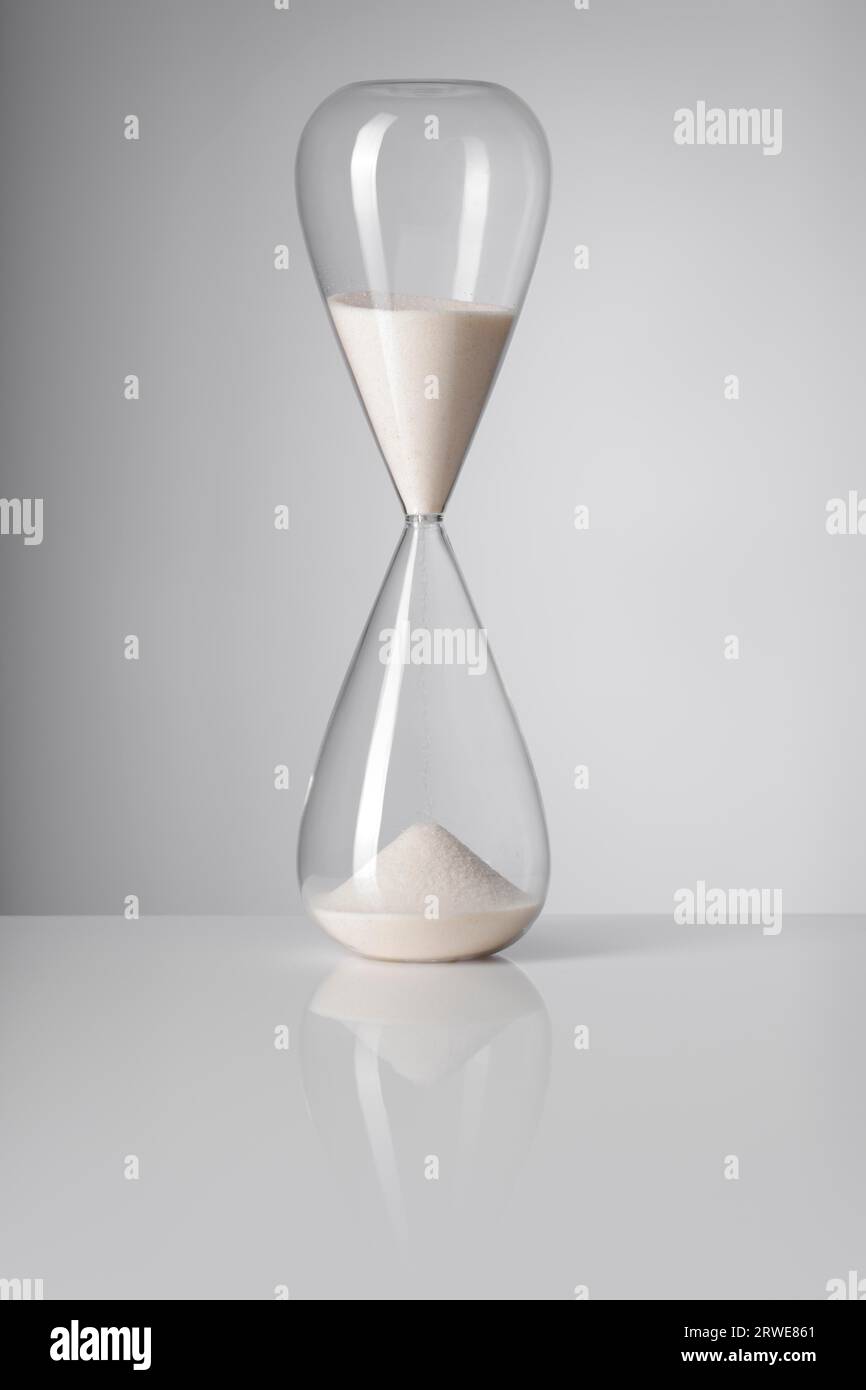A Hourglass on reflective background Stock Photo - Alamy