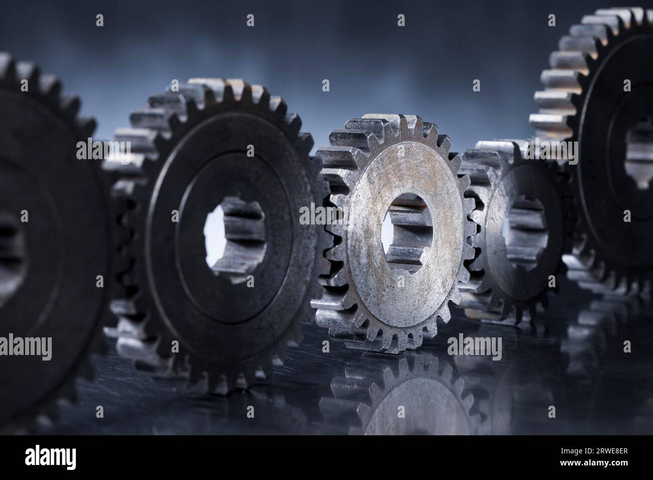 Old worn metallic cog gear wheels, with one gear in spotlight Stock ...