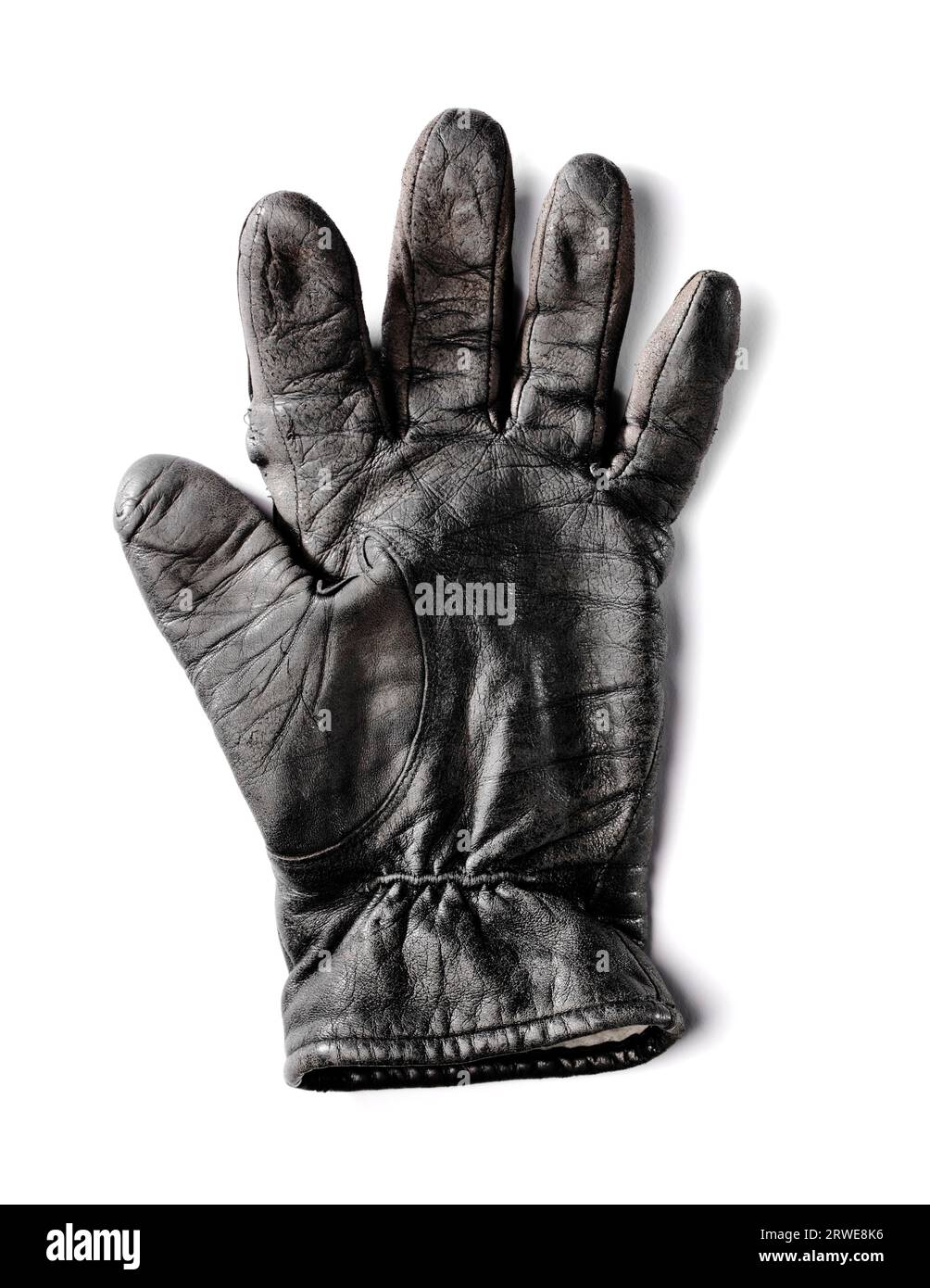 Old worn black leather glove isolated on white with natural shadow ...