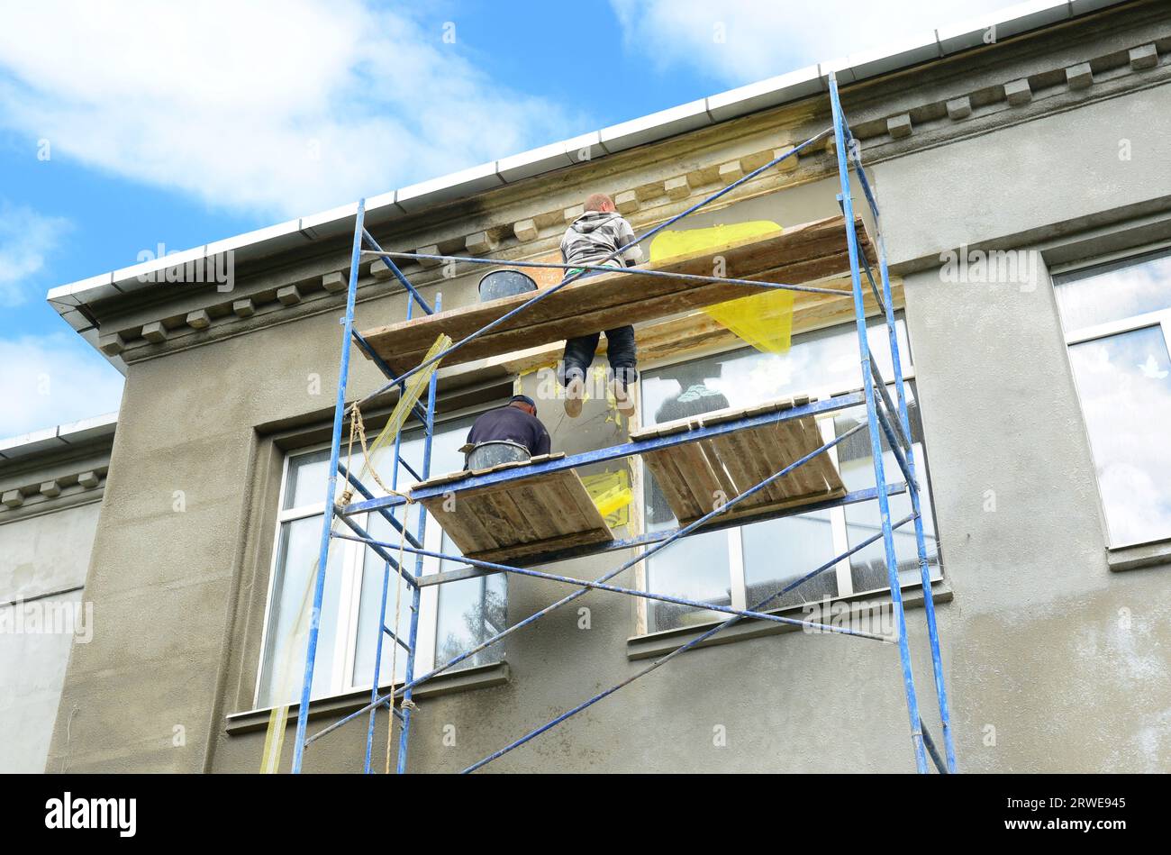 Building contractors plastering external house walls. House renovation ...